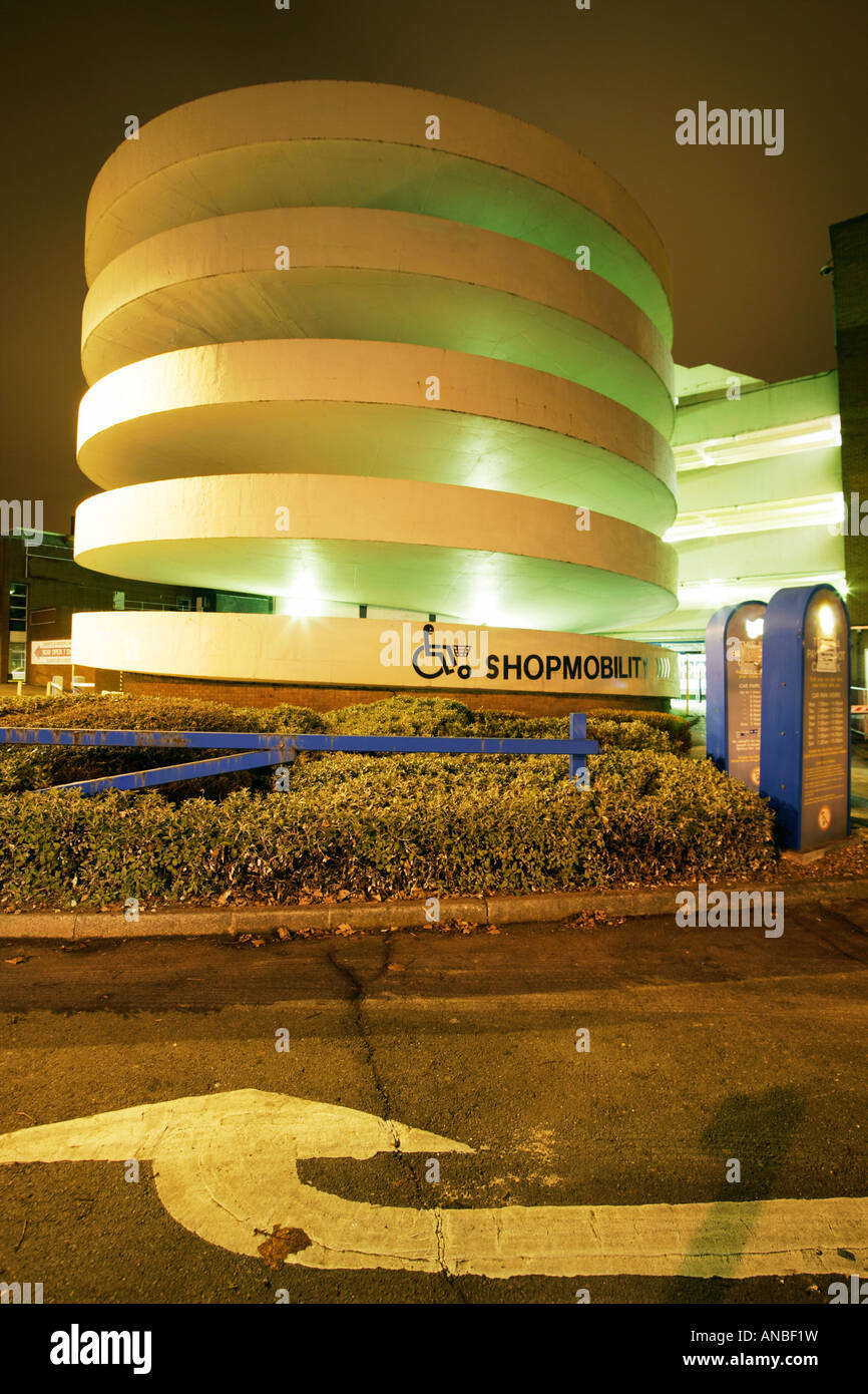 Spiral ramp of multistorey car park lit up at night with a large arrow ...