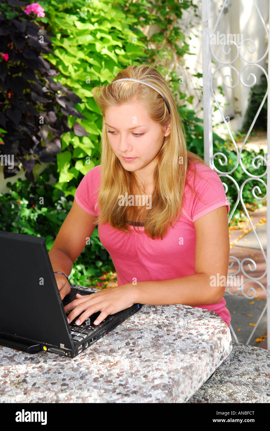Teenage girl typing on a portable computer outside Stock Photo - Alamy