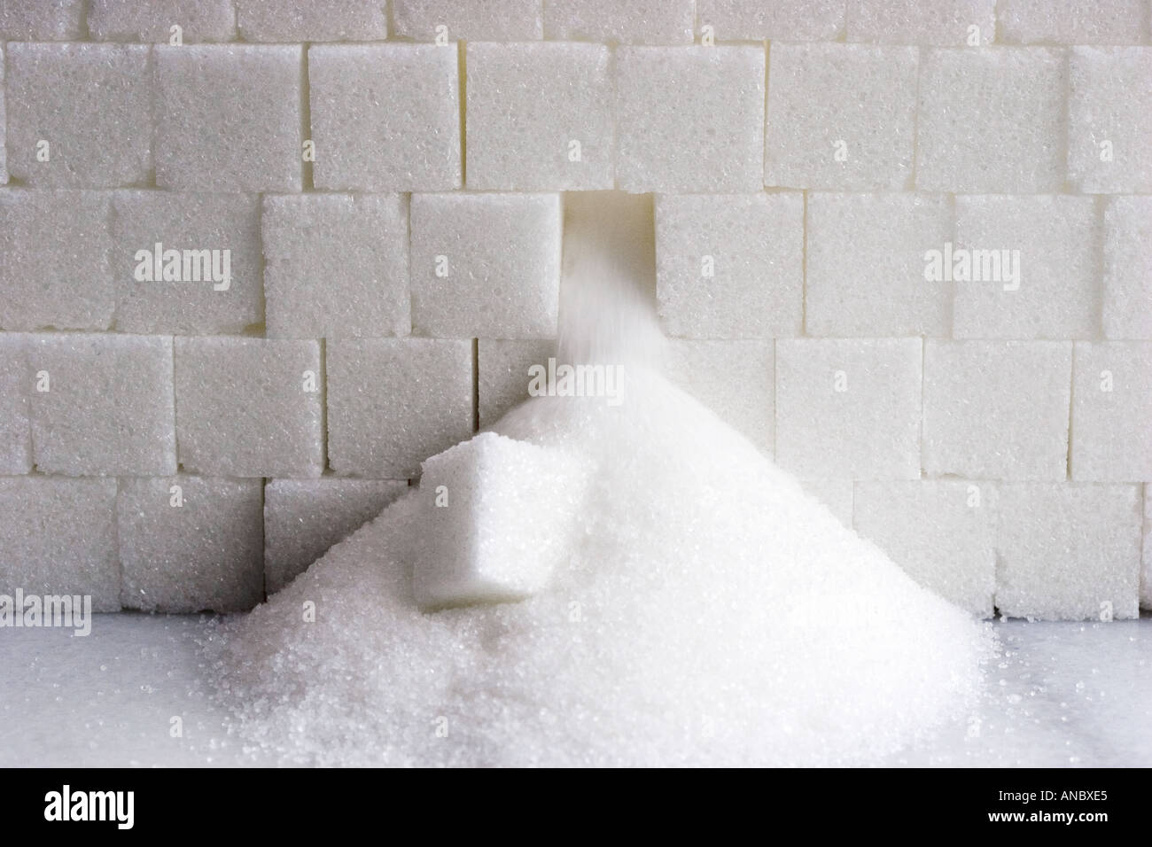 Wall made from Sugar lumps with sugar flowing through a gap Stock Photo ...