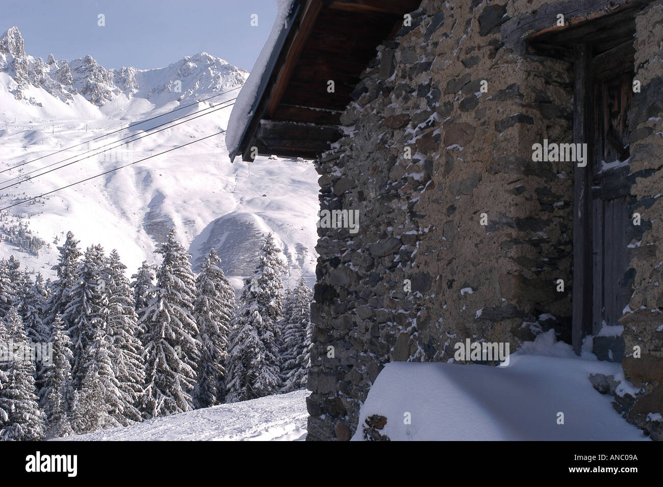 Mountain hut in winter with snow and trees and cable car lines Stock ...