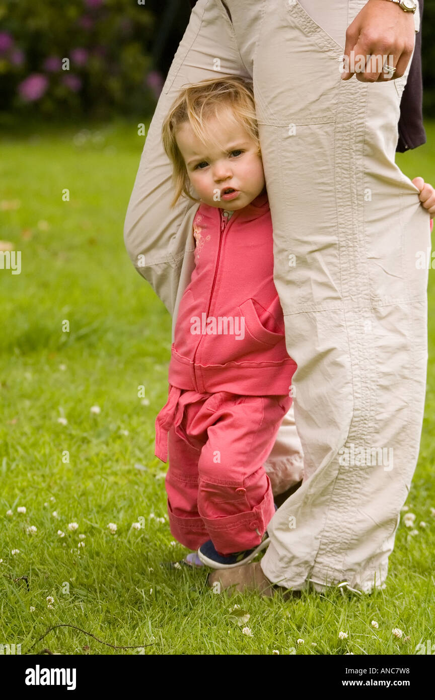 A child scowls back at the camera whilst in the protection of her ...