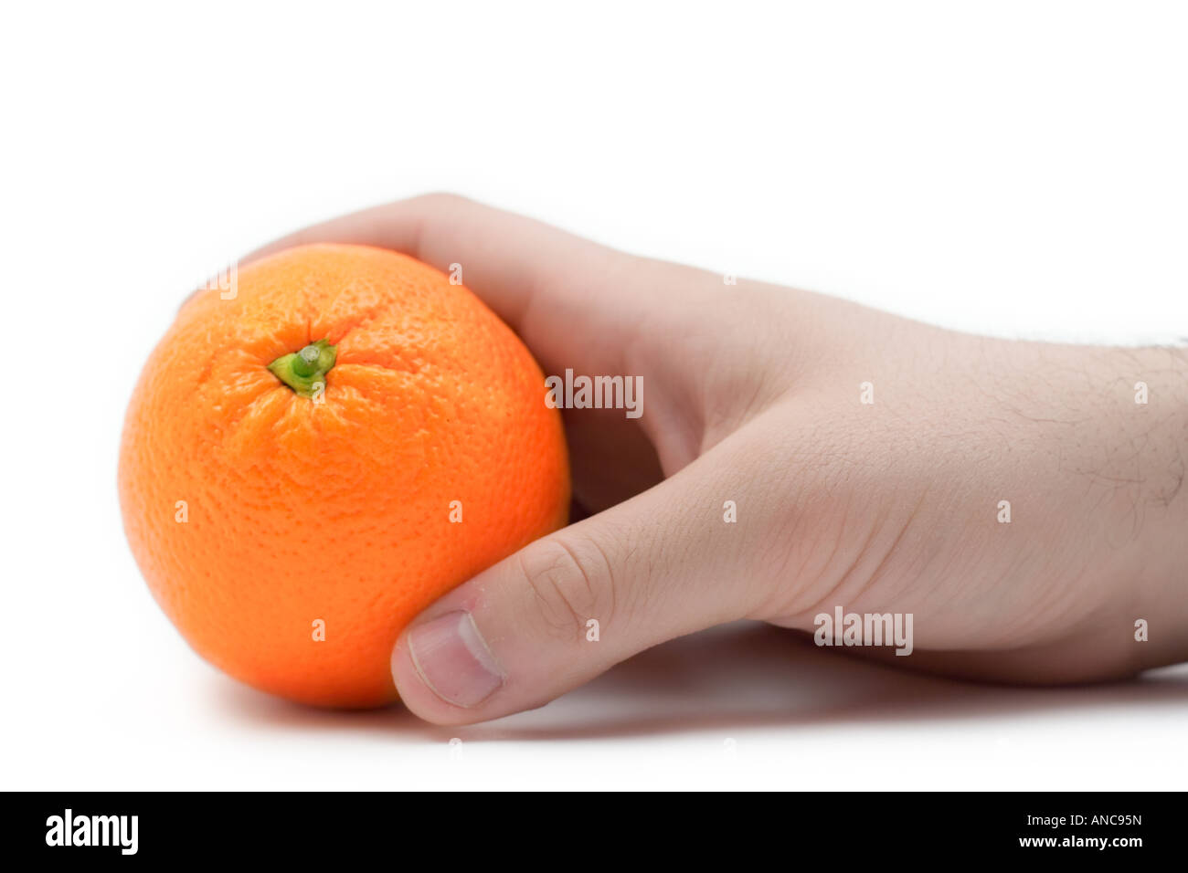 Hand and an orange Stock Photo - Alamy