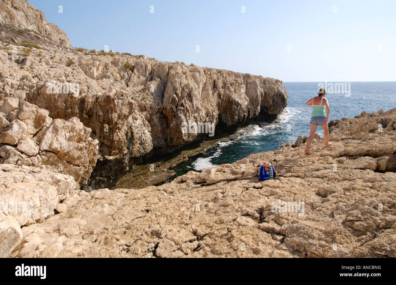Woman in shorts flip flops and tee shirt at sea inlet at Cape Gkreko on ...
