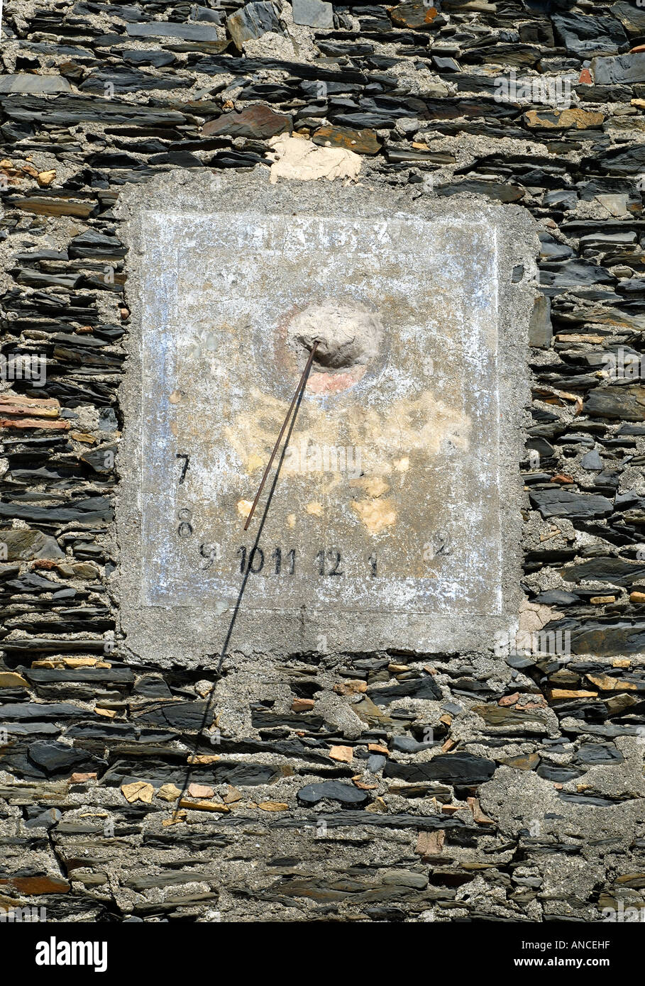 Faded sun dial set in a stone wall Stock Photo - Alamy