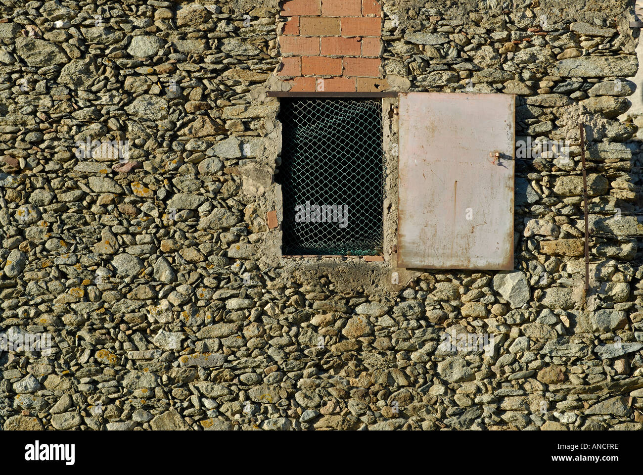 Metal shuttered window in stone wall Stock Photo - Alamy