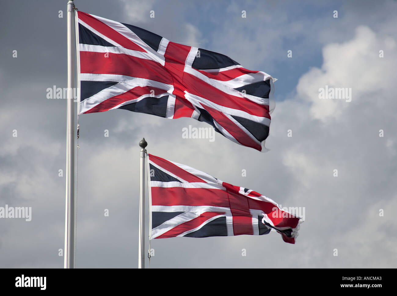 Two British Flags stretched out by a strong wind under a threatening ...