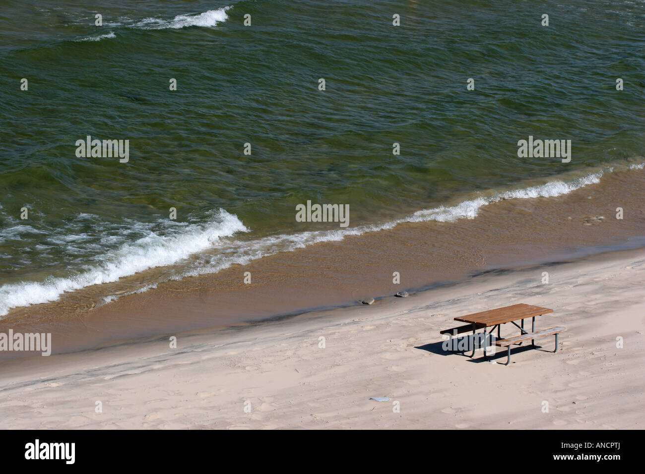 Lake Michigan with empty sandy beach and wooden picnic table from above ...