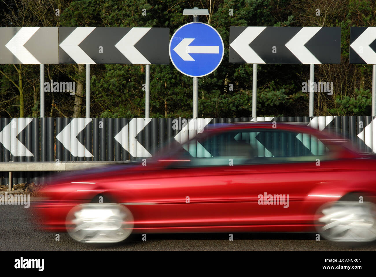 Car speeding across road junction Stock Photo - Alamy