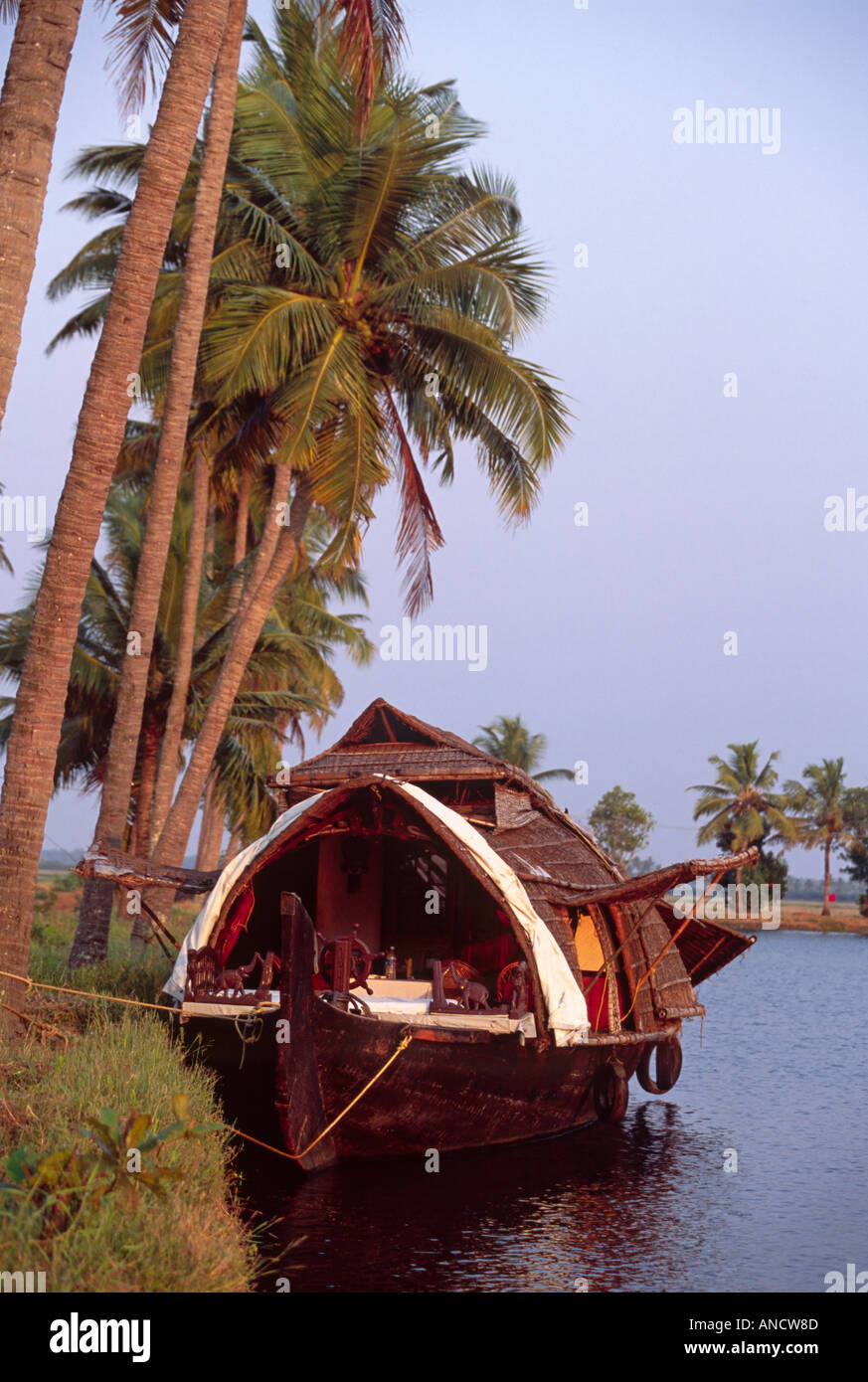 Traditional rice barge moored at the side of a river on the backwaters ...