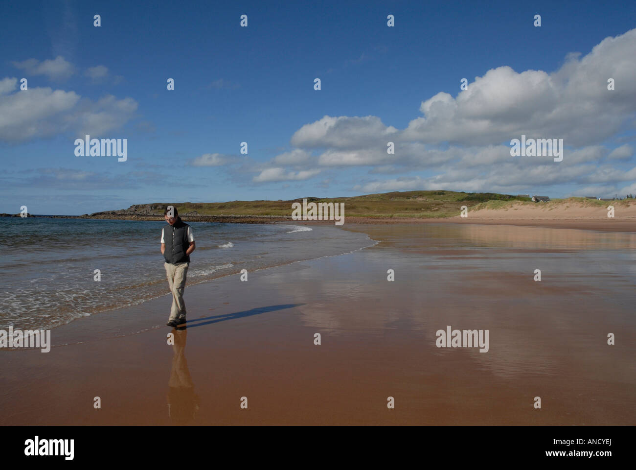 Man walking with his head down along a beach Stock Photo - Alamy