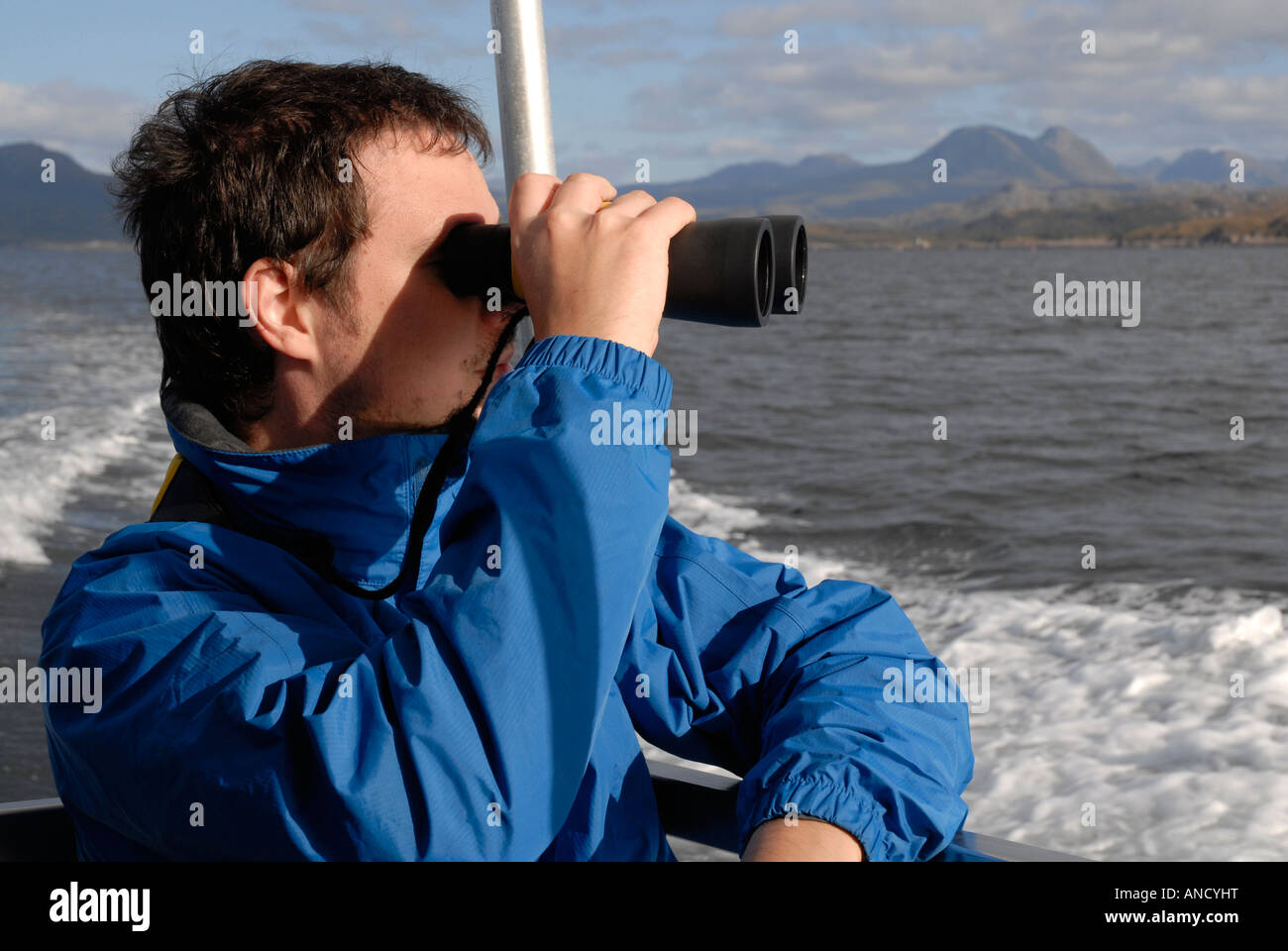 Side view of a man looking through binoculars Stock Photo - Alamy