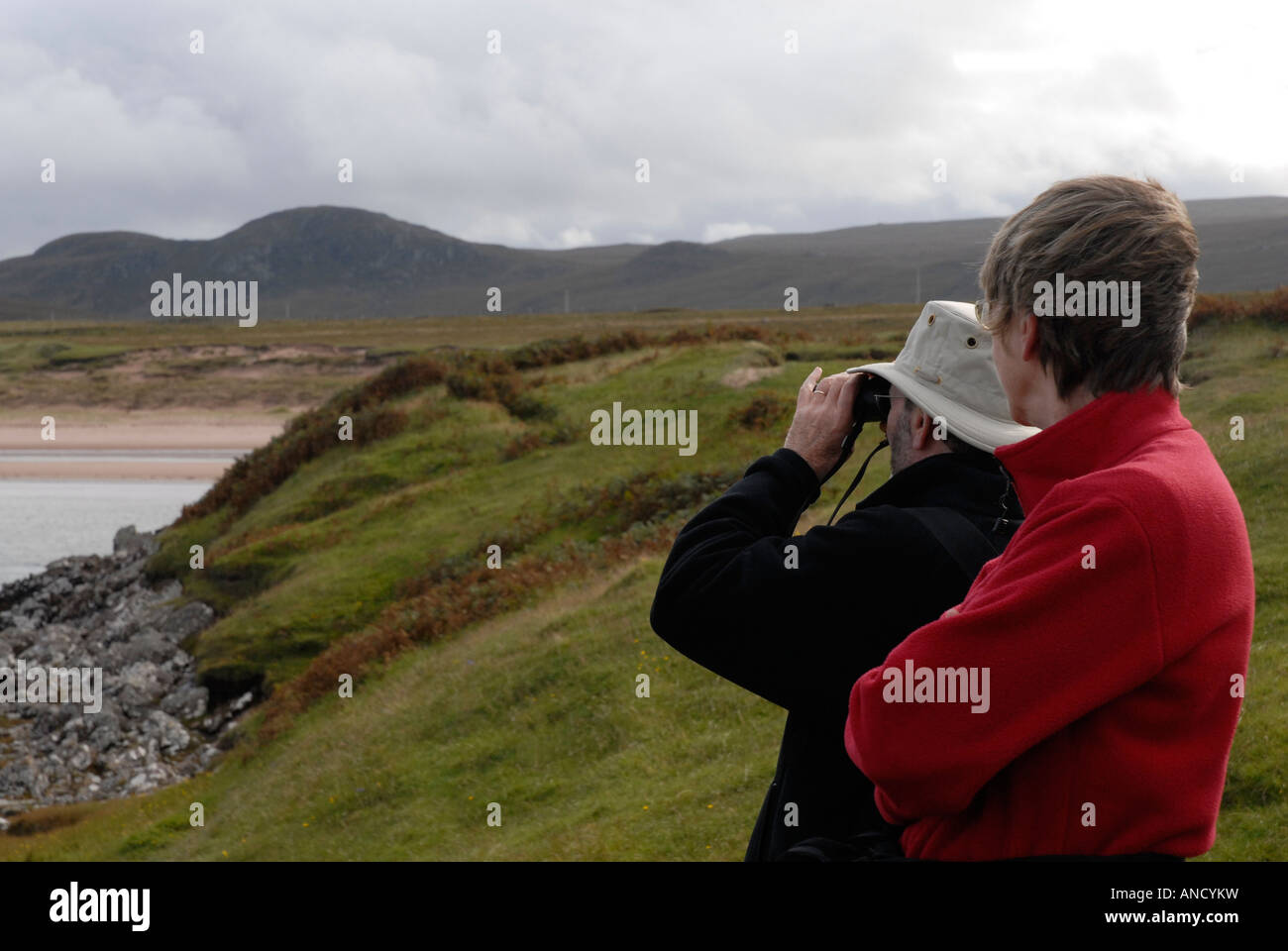 Couple standing on a coastal path looking through binoculars Stock ...