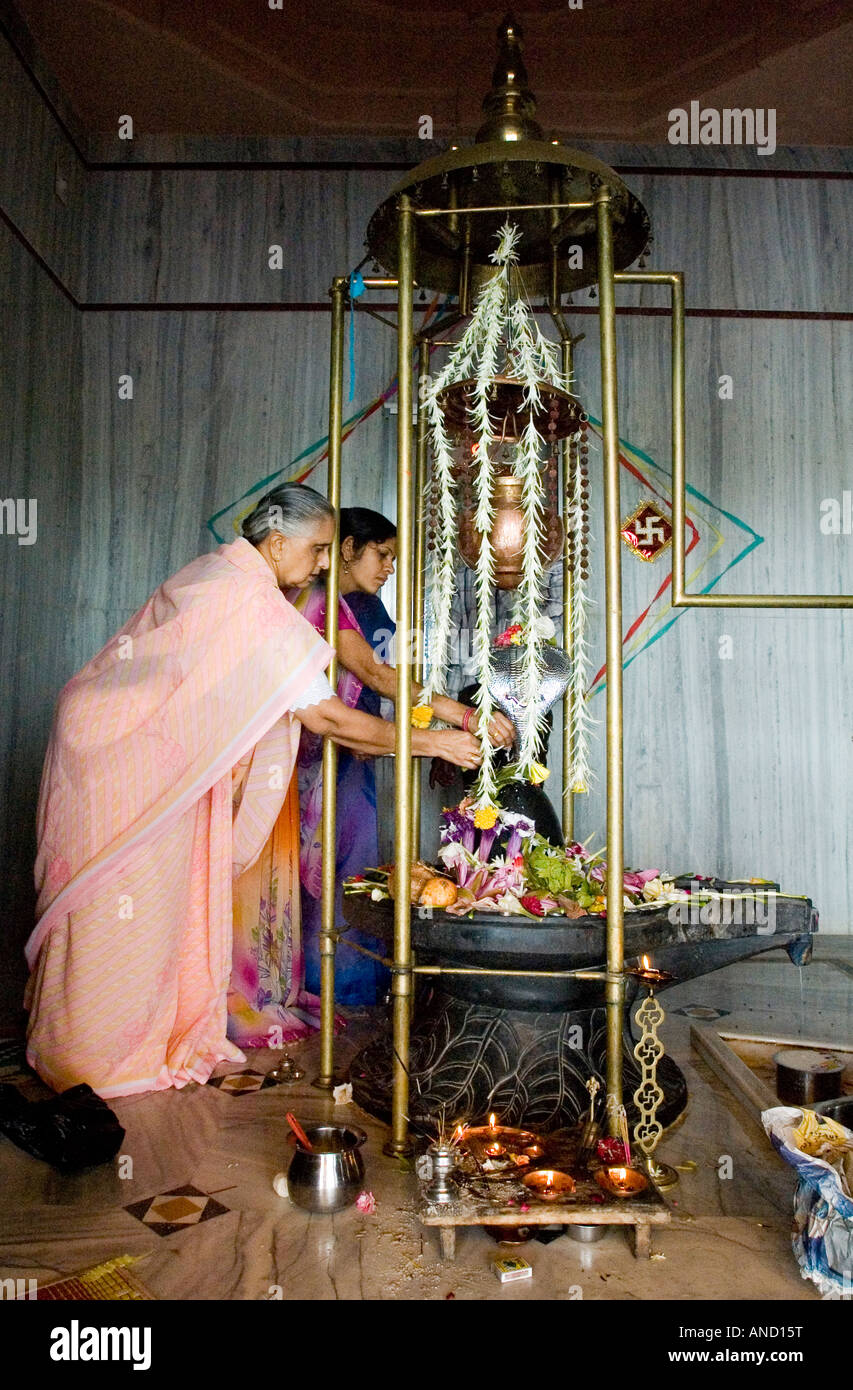 Two hindu women pray to Lord Shiva on Shivratri in a temple in India ...