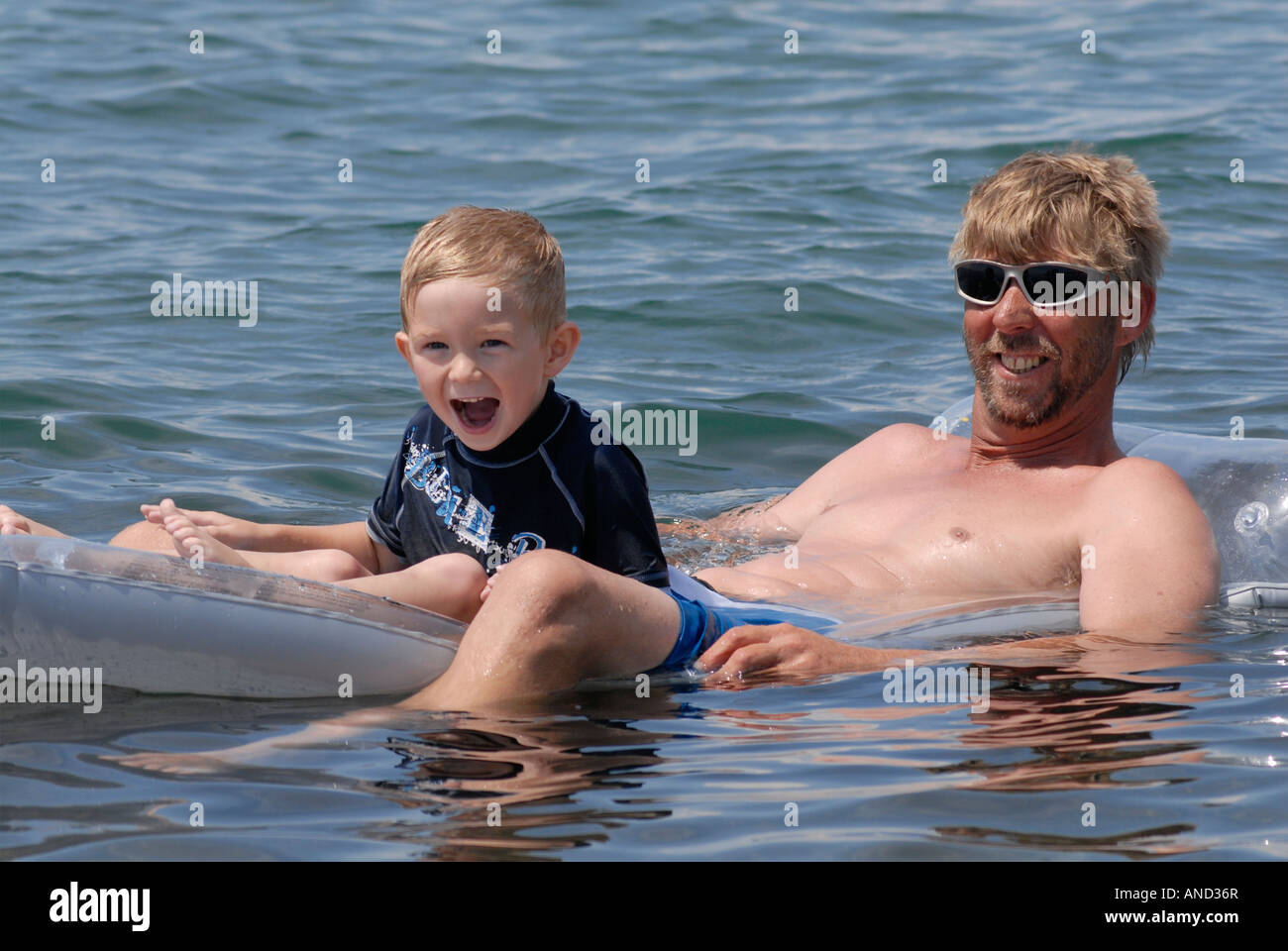Father and son relaxing on an inflatable lilo in the sea Stock Photo ...