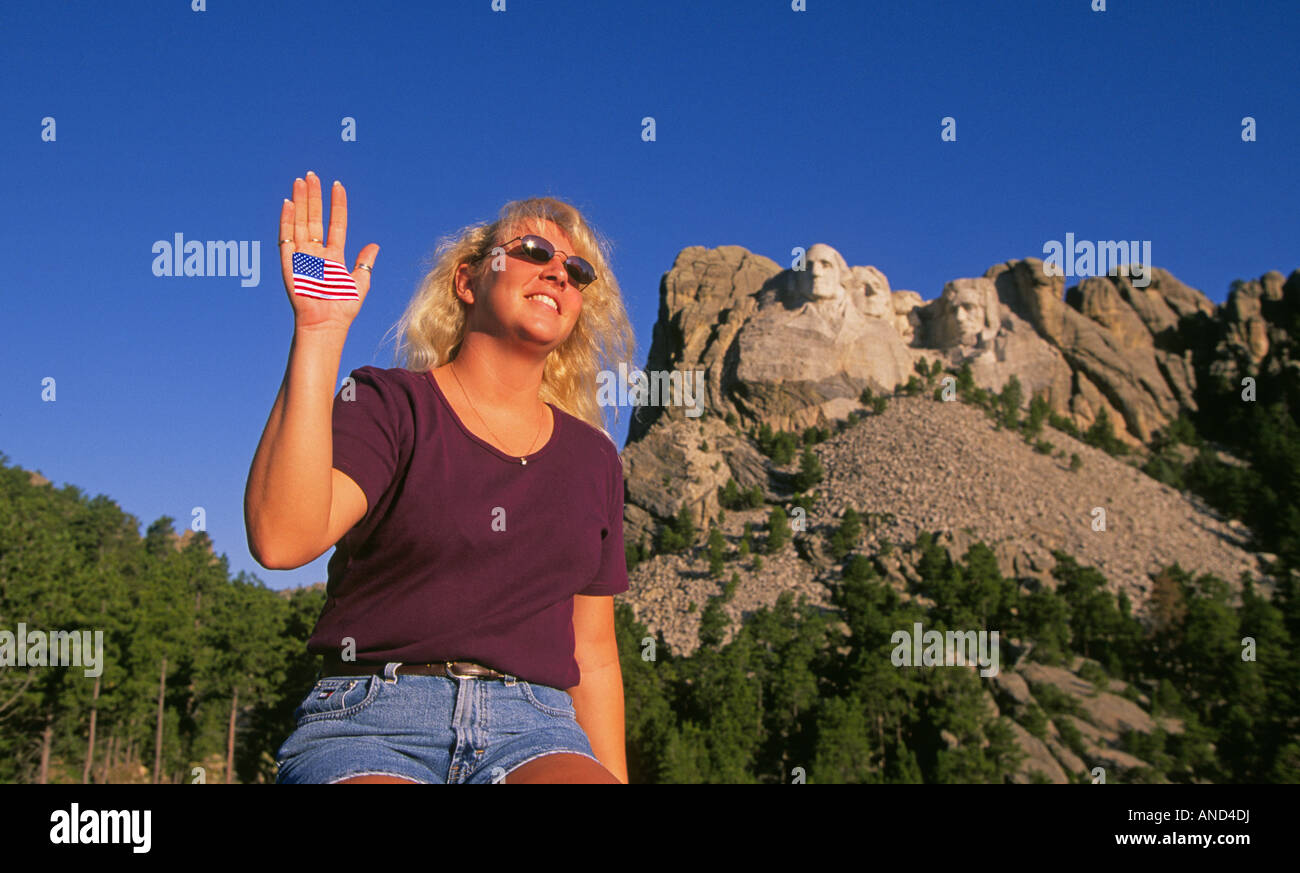 A woman with an American flag painted on her hand sits in front of ...