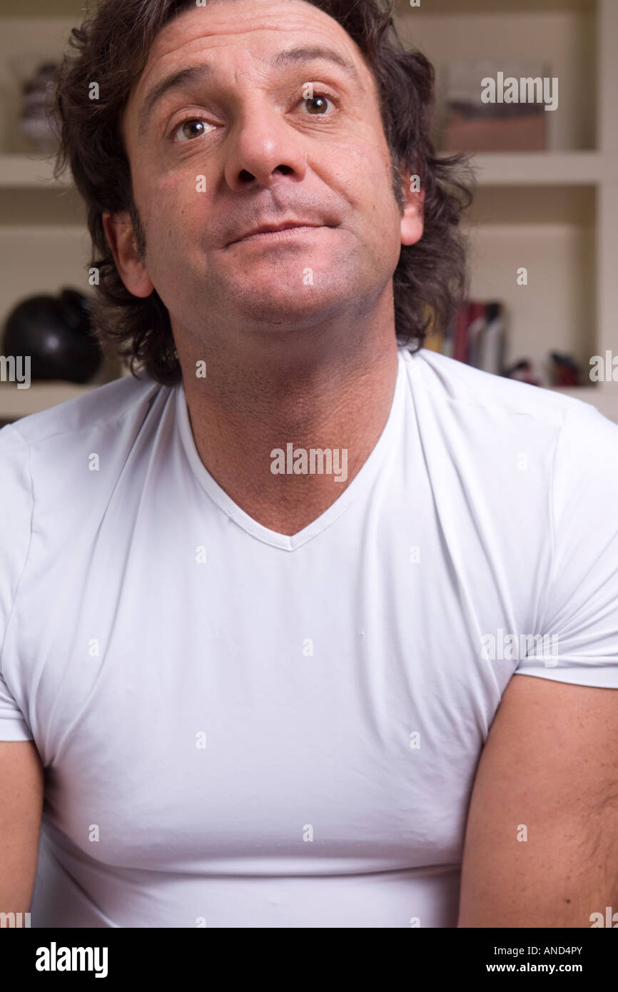 Man sitting indoor looking above with resigned expression Stock Photo ...