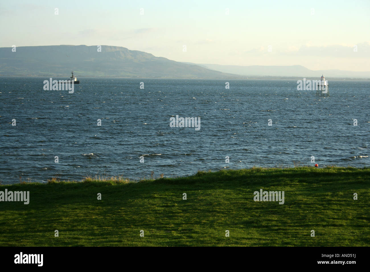 the edge of Lough Foyle in evening light, towards Binevenagh mountain ...