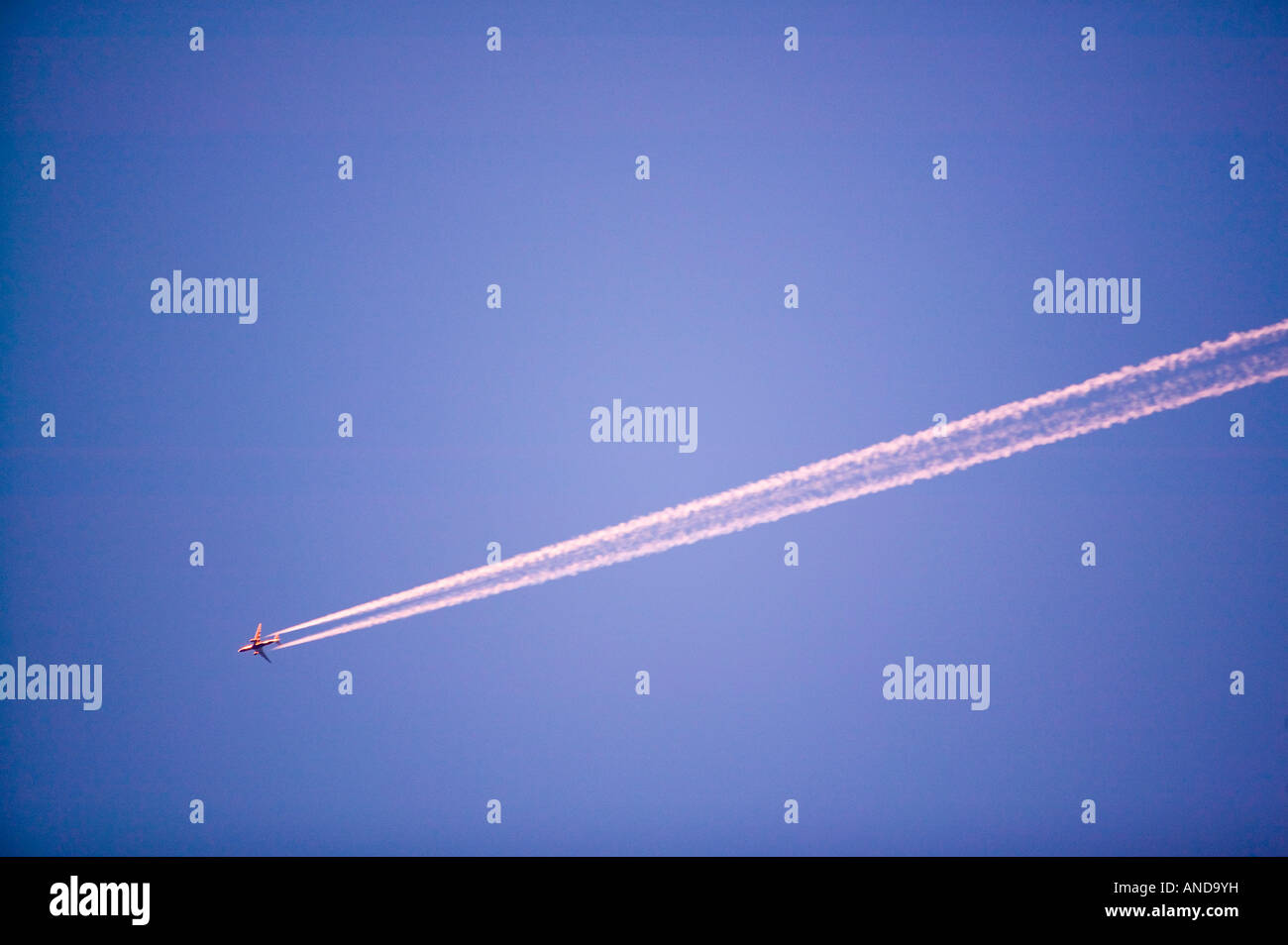 a jet plane flying at sunset Stock Photo - Alamy