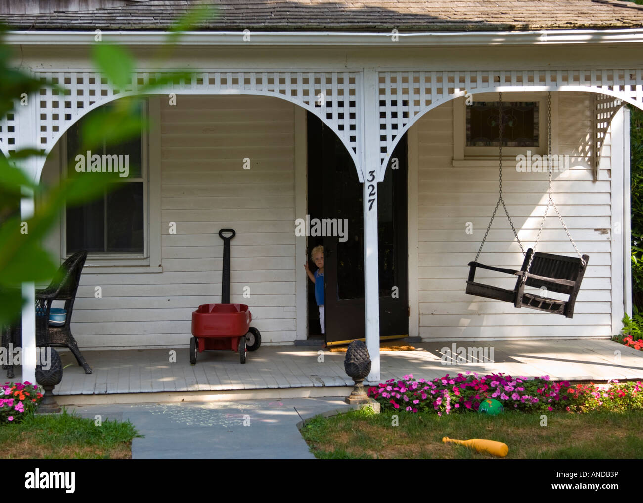 Child looking out the door on the porch Stock Photo - Alamy