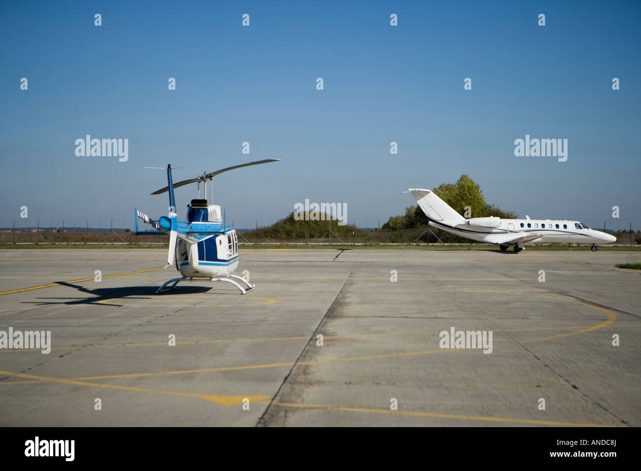 helicopter and private jet plane parked in the aeroport service area ...