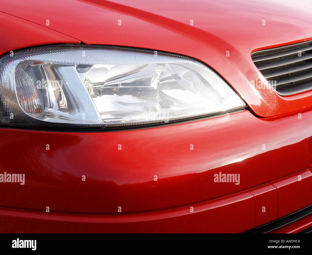 Red car seen from the left front corner Stock Photo - Alamy