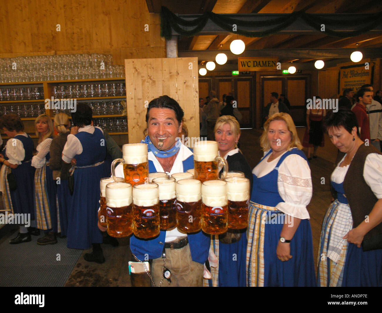 Waitress dressed in dirndl serving Liter glasses of beer in Oktoberfest ...