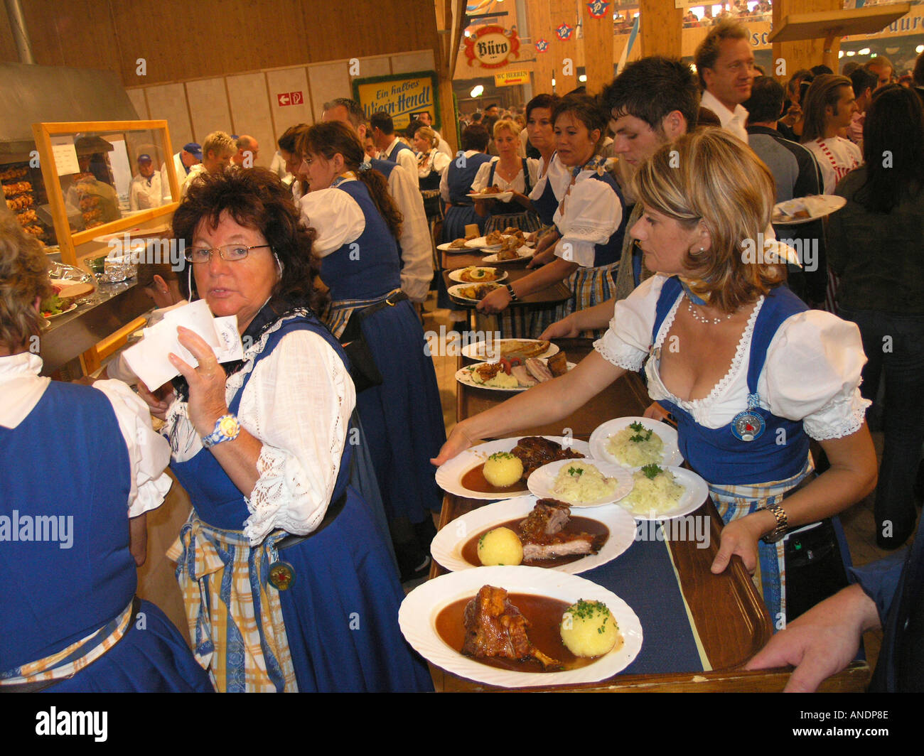 Server waitress carry tray of roasted chicken or roasted meat around in ...
