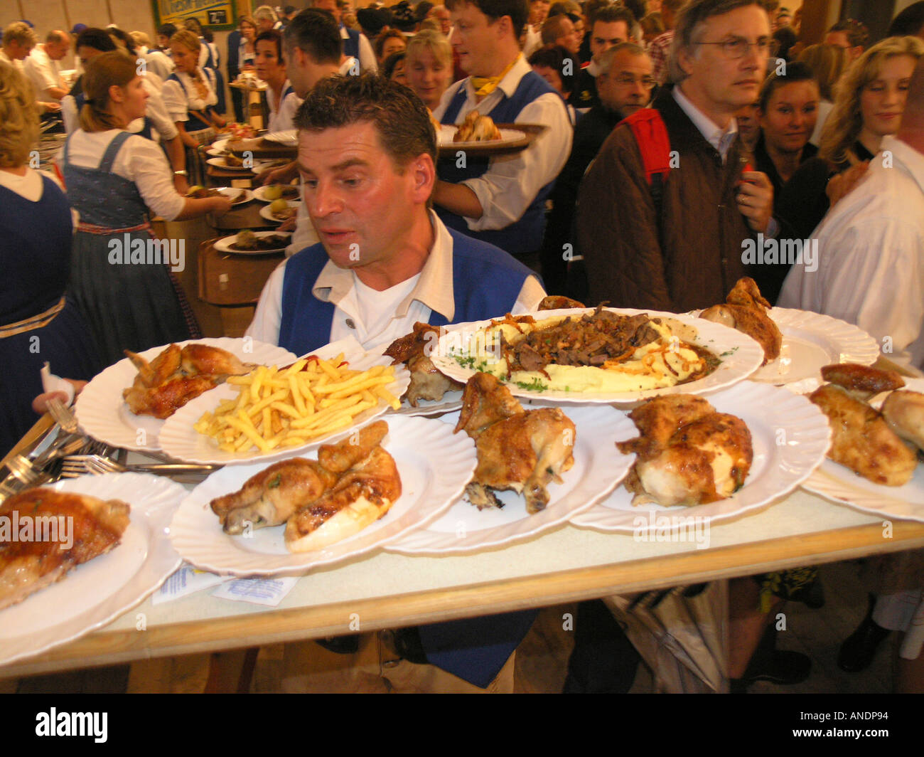 Server waitress carry tray of roasted chicken or roasted meat around in ...