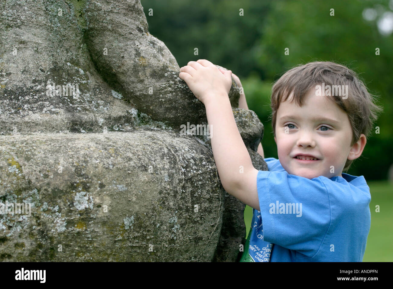A small boy playing on a stone urn in the grounds of Rufford Abbey ...