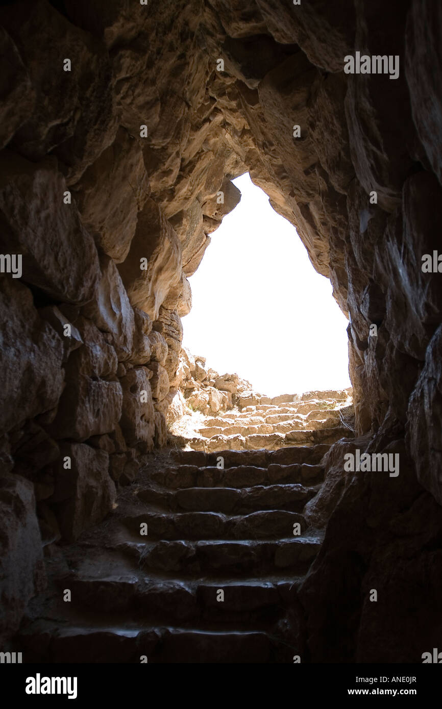Ancient Mycenae cobbled stairs in shadow with sunny triangular entrance ...