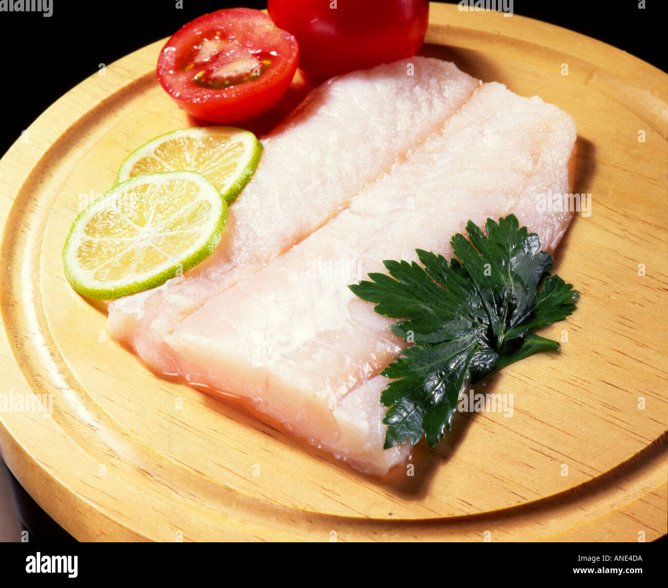 Fish raw fresh mahi mahi fillets with tomatoes and parsley on round ...