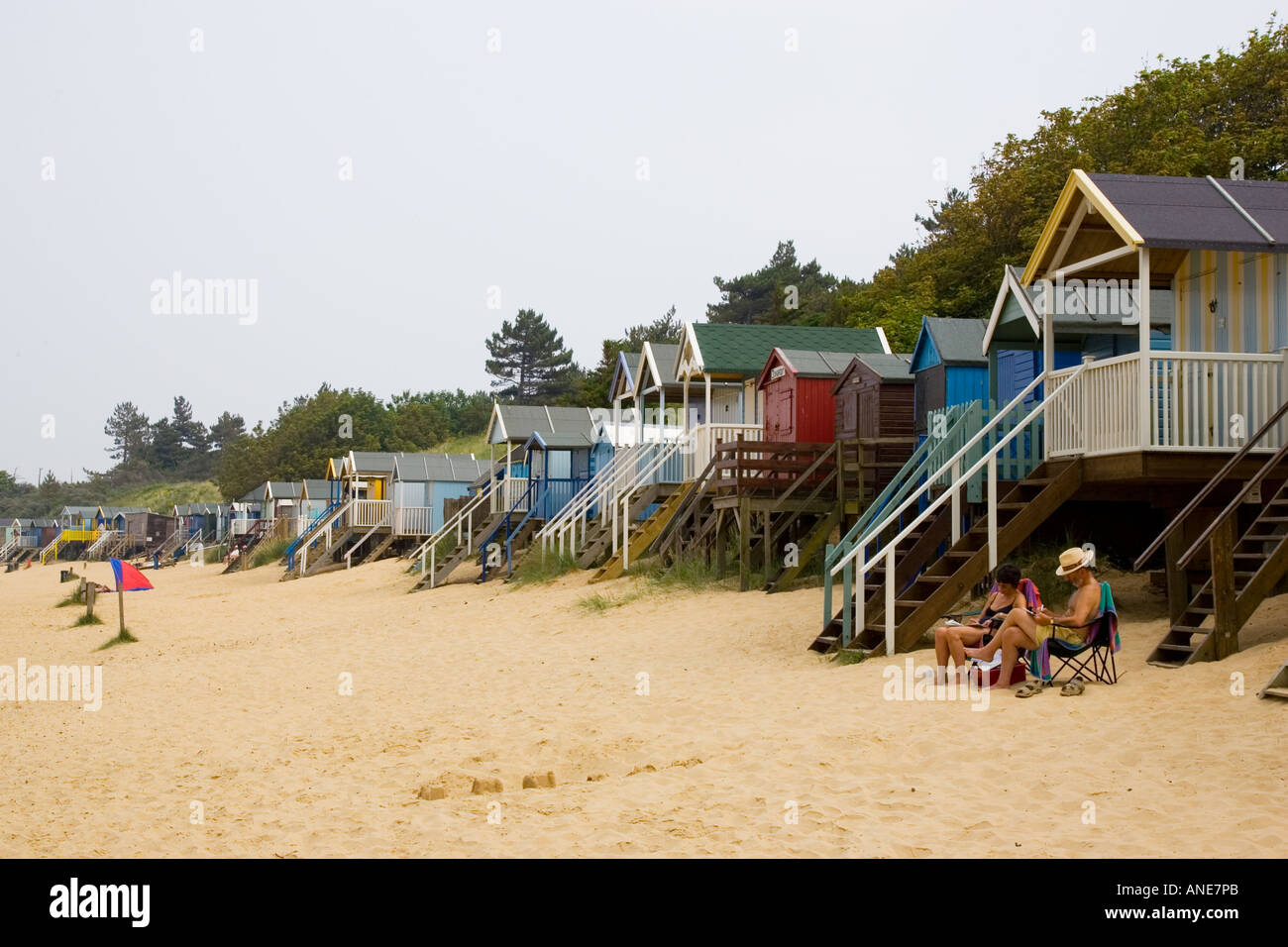 Couple sitting outside beach huts hi-res stock photography and images ...