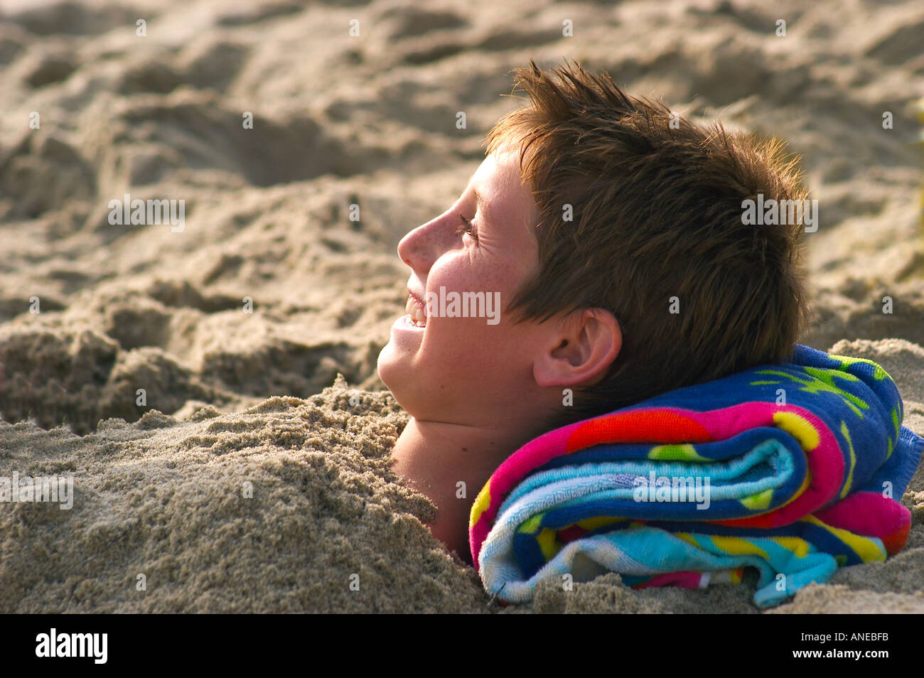 boy buried in beach sand Stock Photo - Alamy