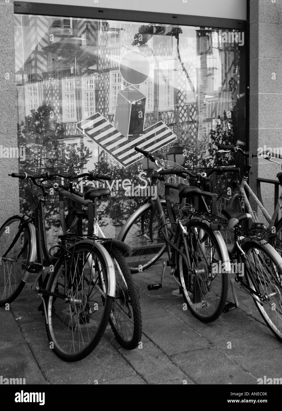Bicycles at cycle racks in front of shop window with reflection of ...