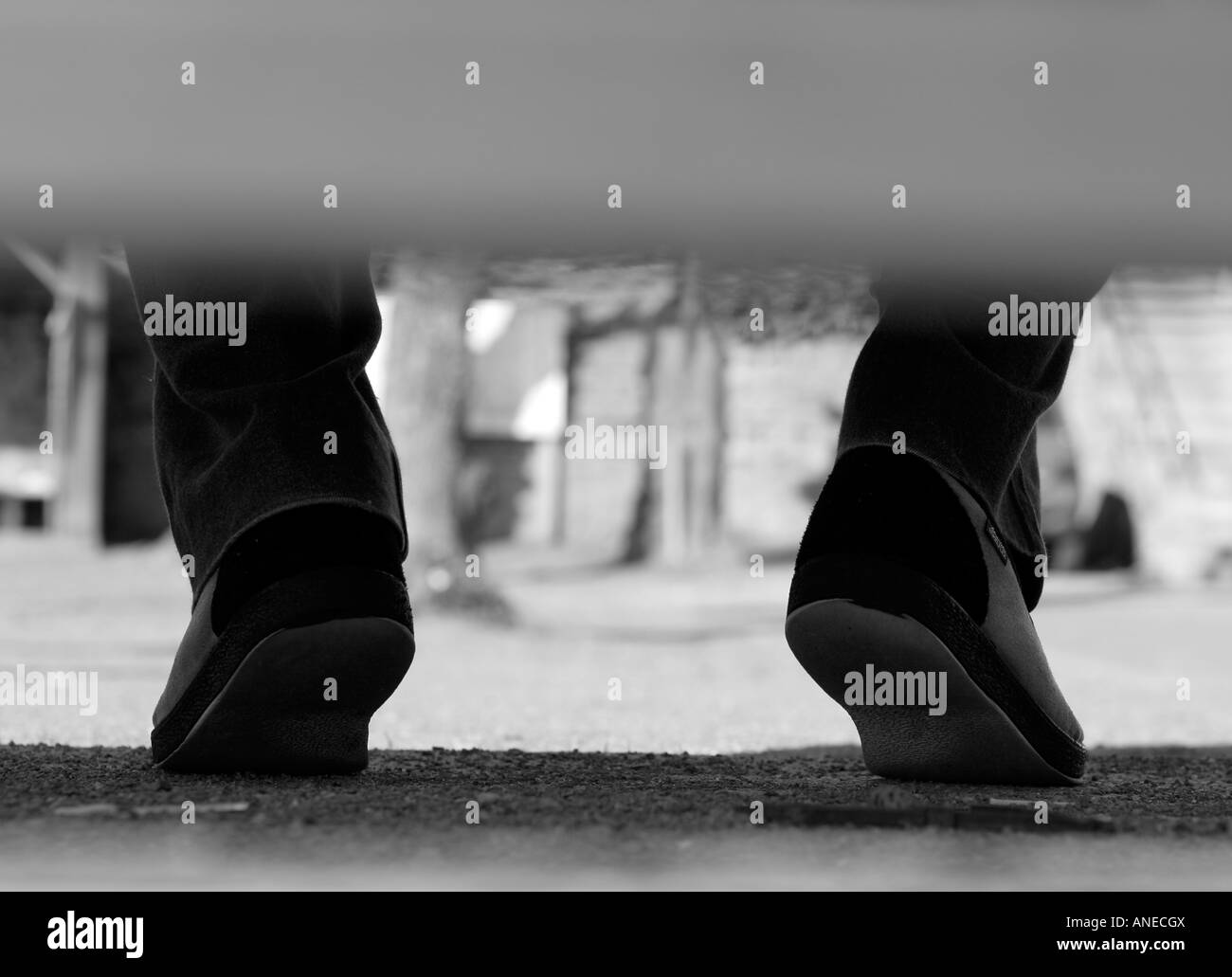 Rear worms eye view of the feet of a man sitting on a bench Stock Photo ...