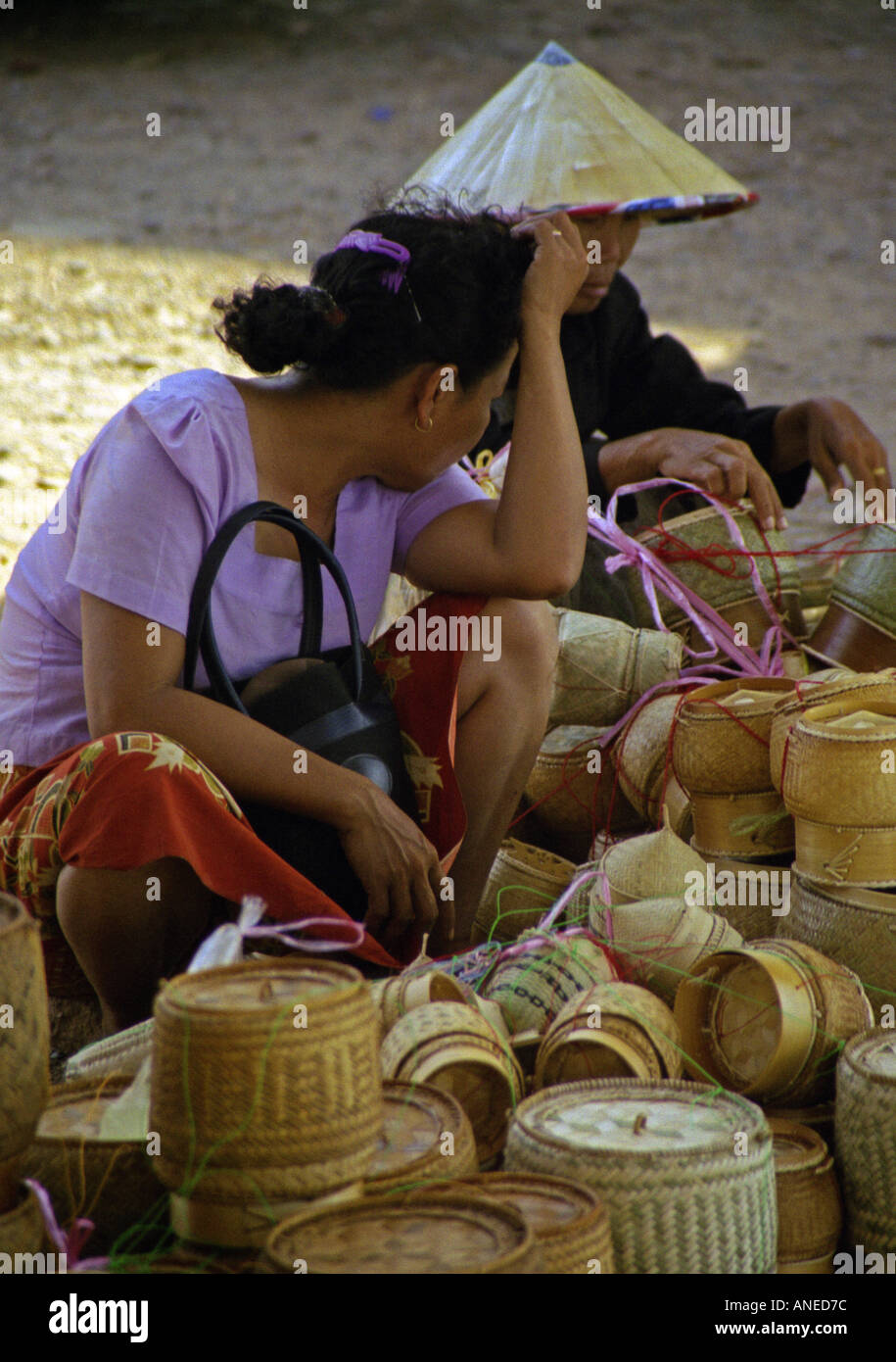 Indigenous women with traditional conical straw hat sit sell handmade ...