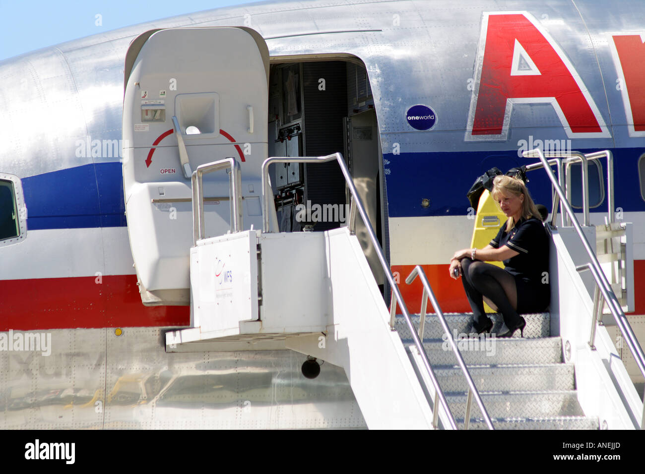 Flight Attendant Sitting on the Boarding Ladder of an Airplane in ...