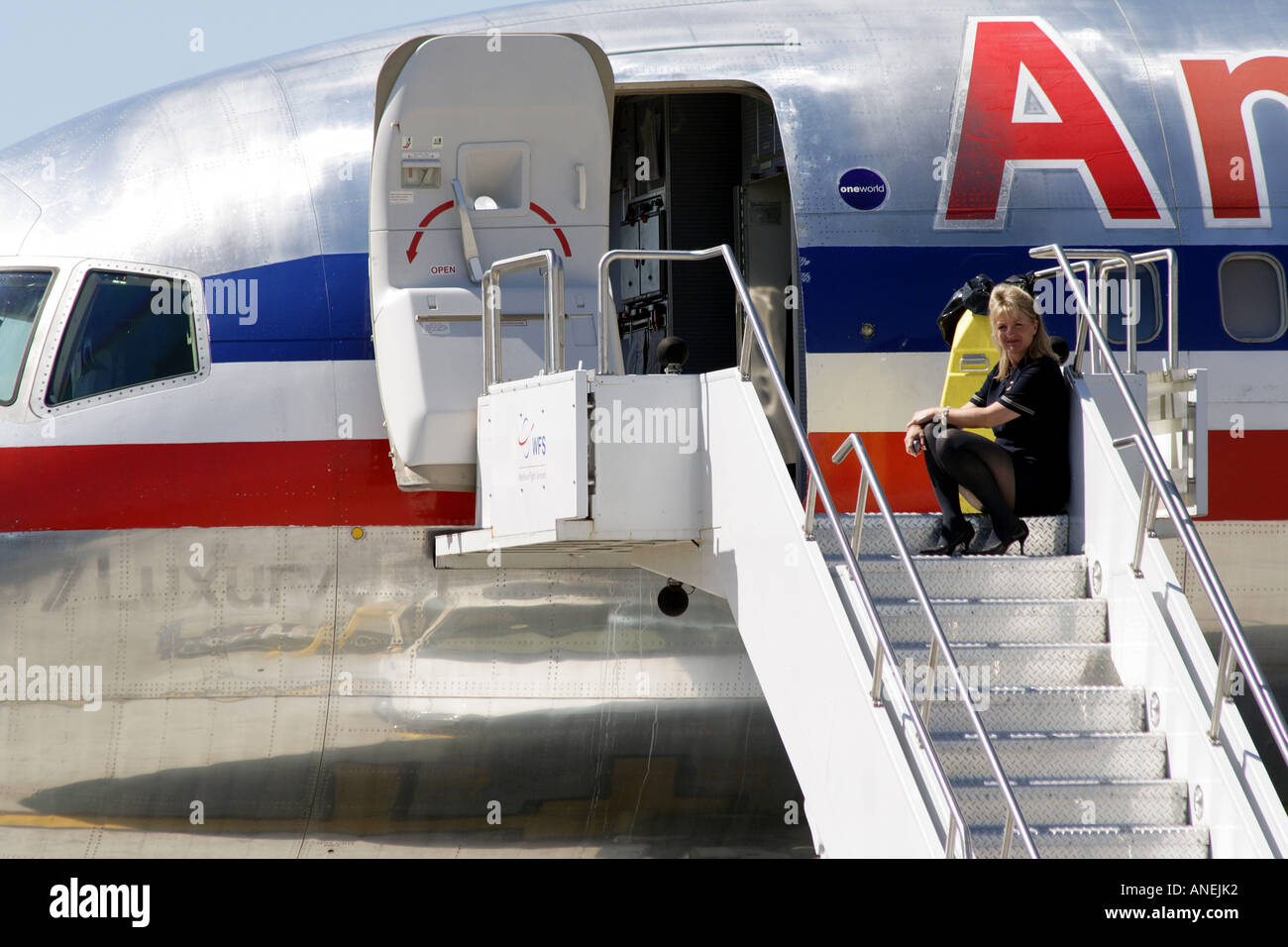 Flight Attendant Sitting on the Boarding Ladder of an Airplane in ...