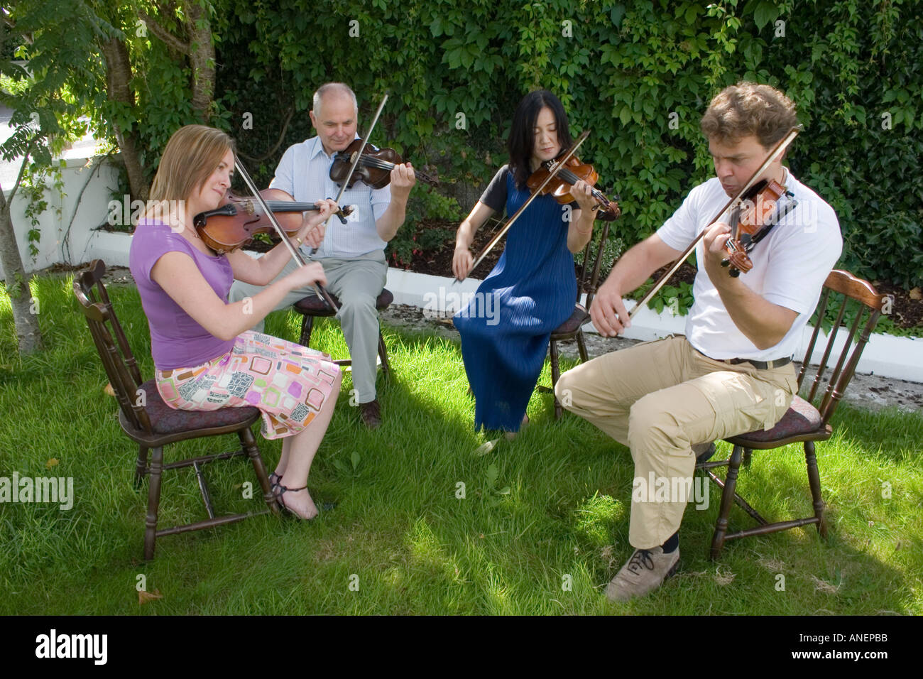 Group of Irish musicians mixed races playing music together outdoors in ...