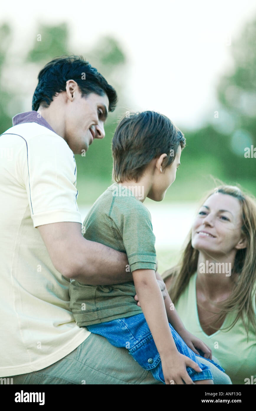 Boy with parents, sitting on father's lap, looking at mother Stock ...