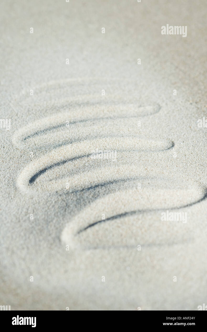 Squiggly pattern traced in sand Stock Photo - Alamy