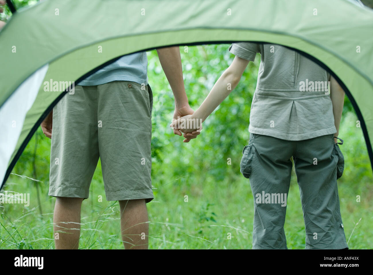 Young couple holding hands, seen through tent Stock Photo - Alamy