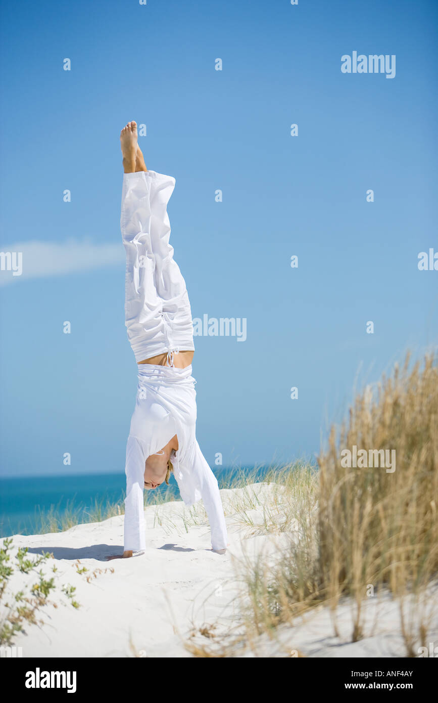 Young woman doing handstand on beach hi-res stock photography and ...