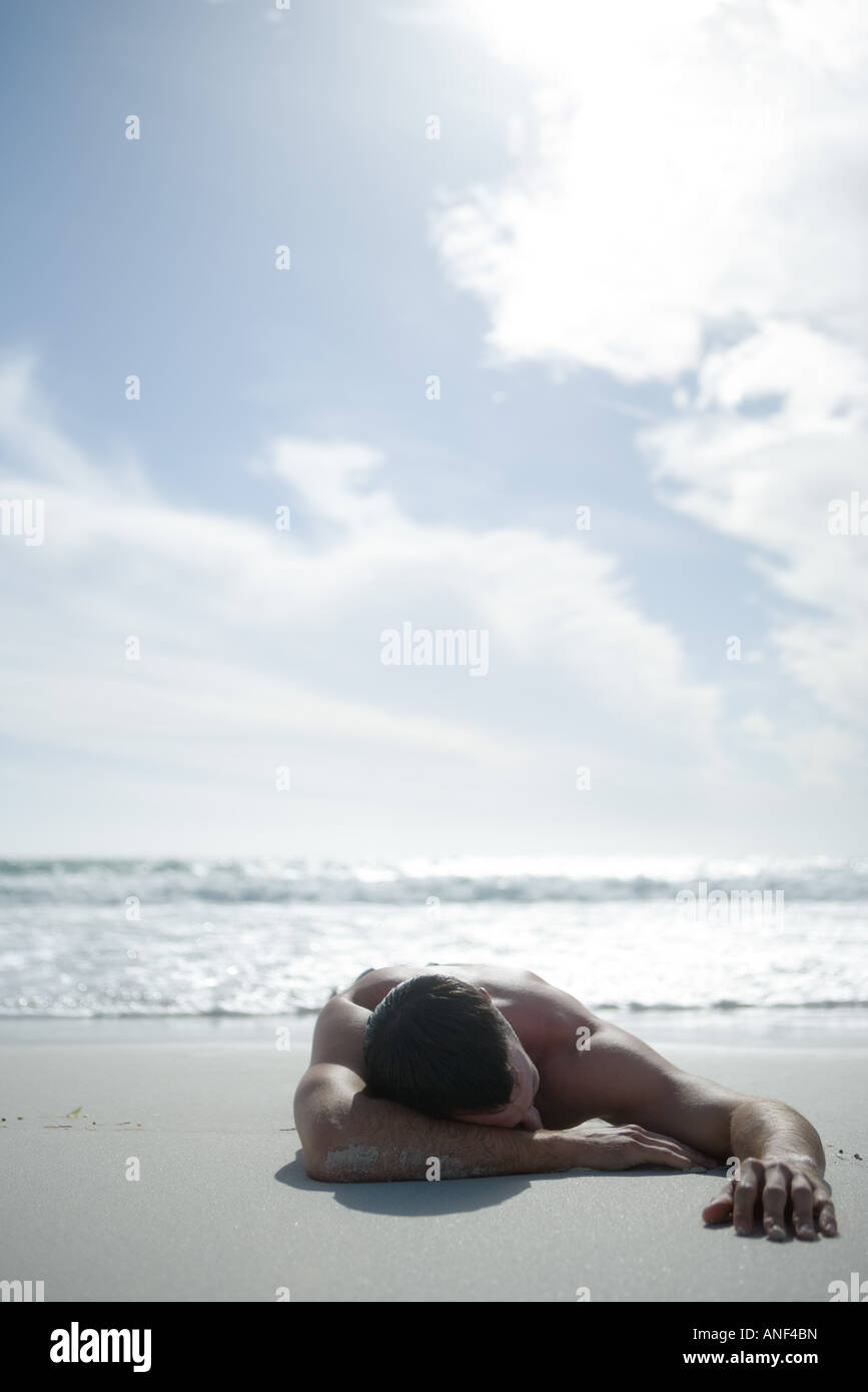 Man lying on beach Stock Photo - Alamy