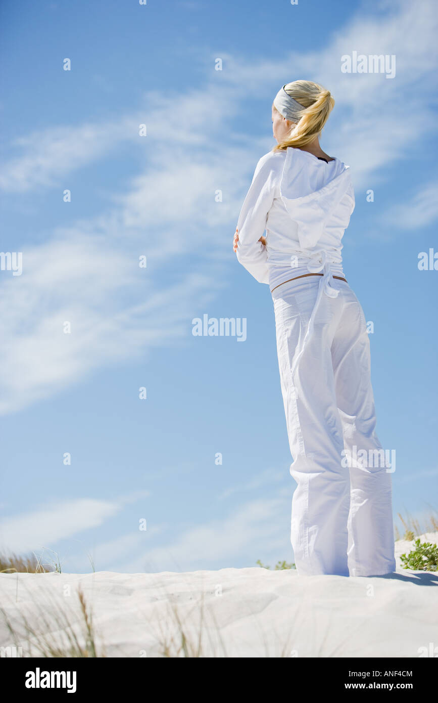 Young woman standing on dune, low angle, rear view Stock Photo - Alamy