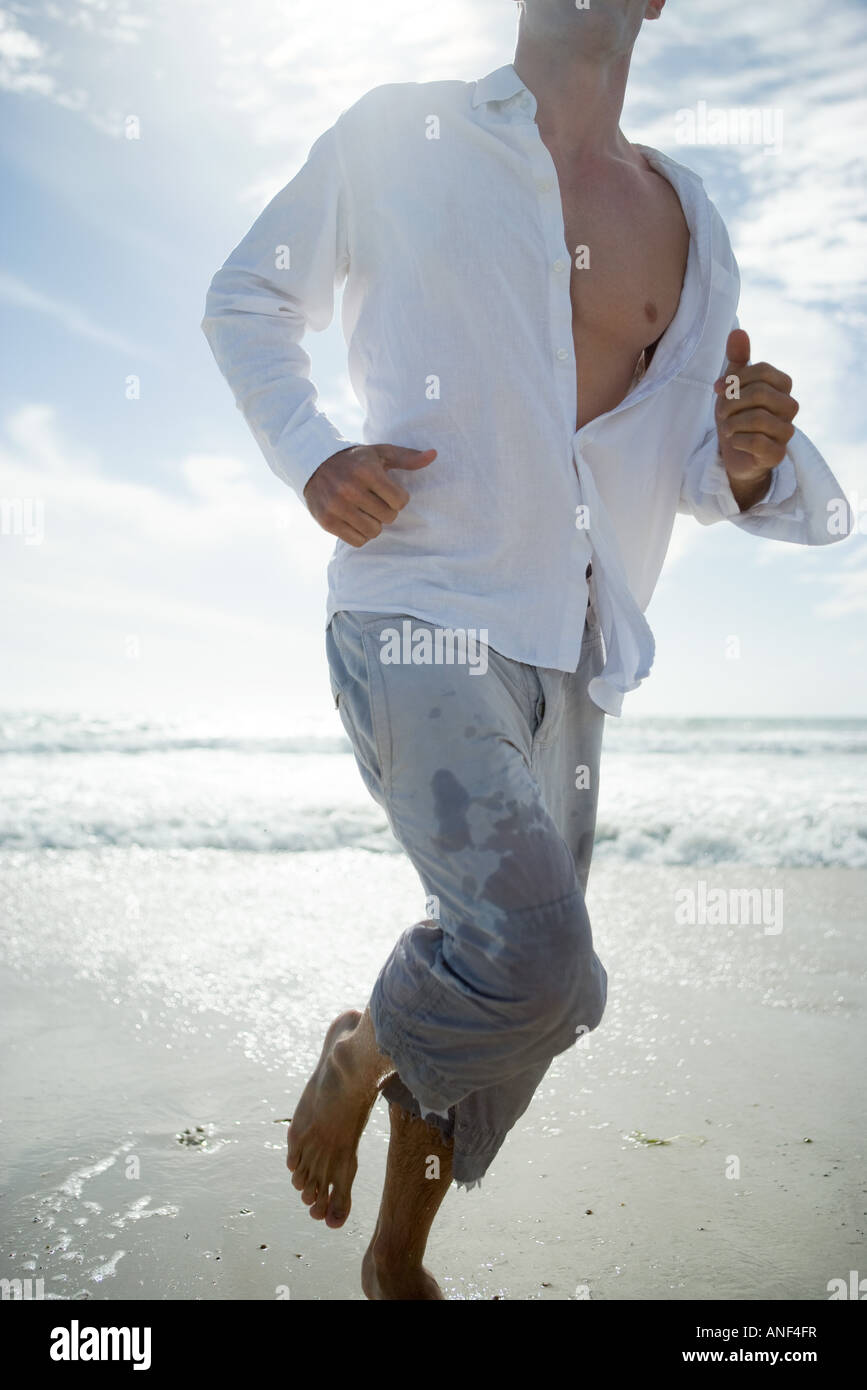 Man running on beach, neck down Stock Photo - Alamy