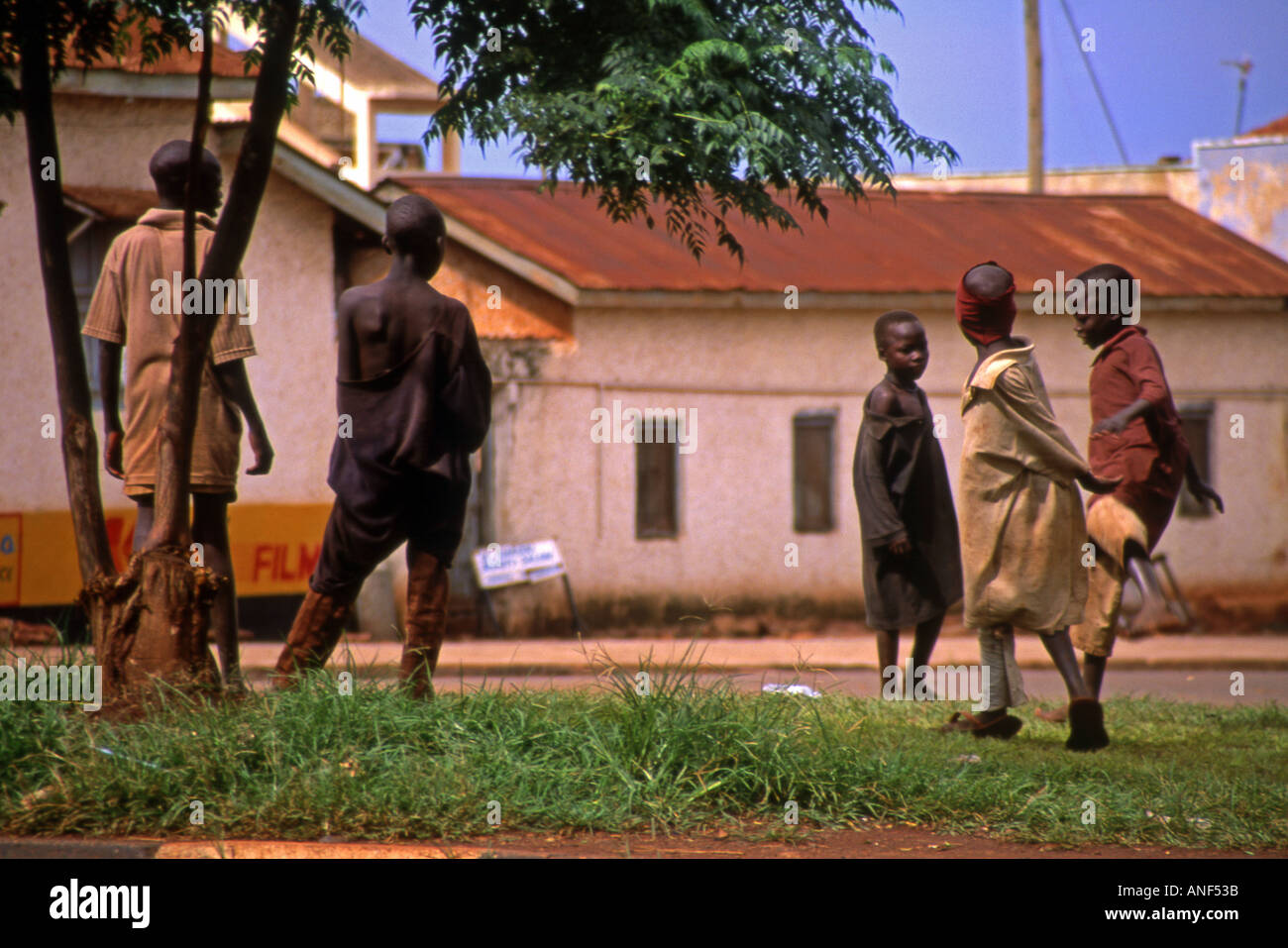 Group of orphan street children poorly dressed play soccer acrobatic ...