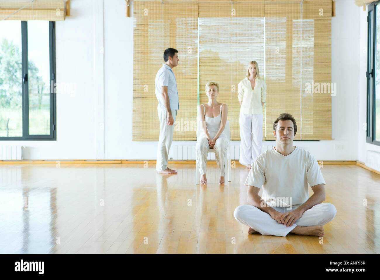 Four adults in various forms of meditation Stock Photo - Alamy