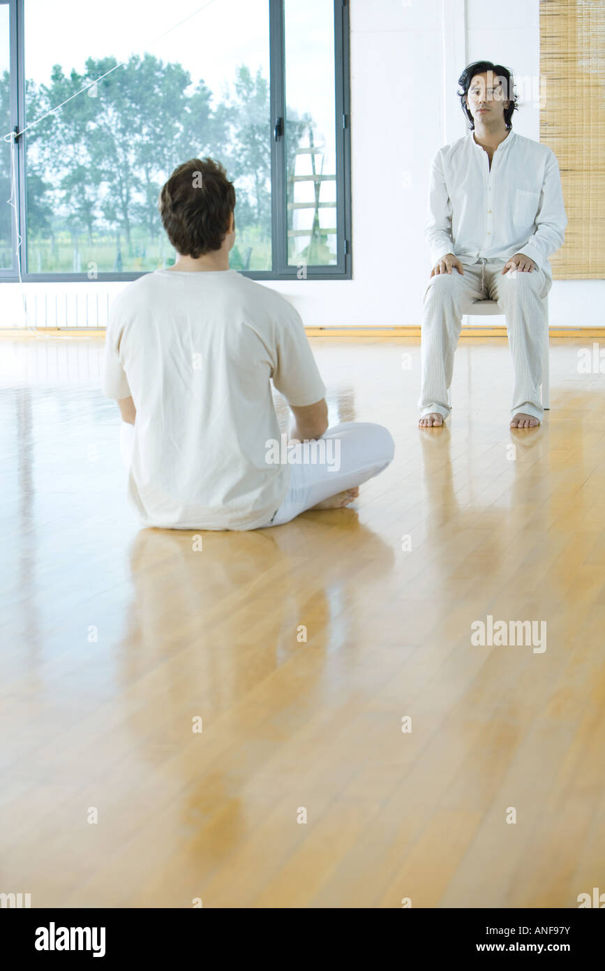 Two men facing each other in alternative therapy session Stock Photo ...