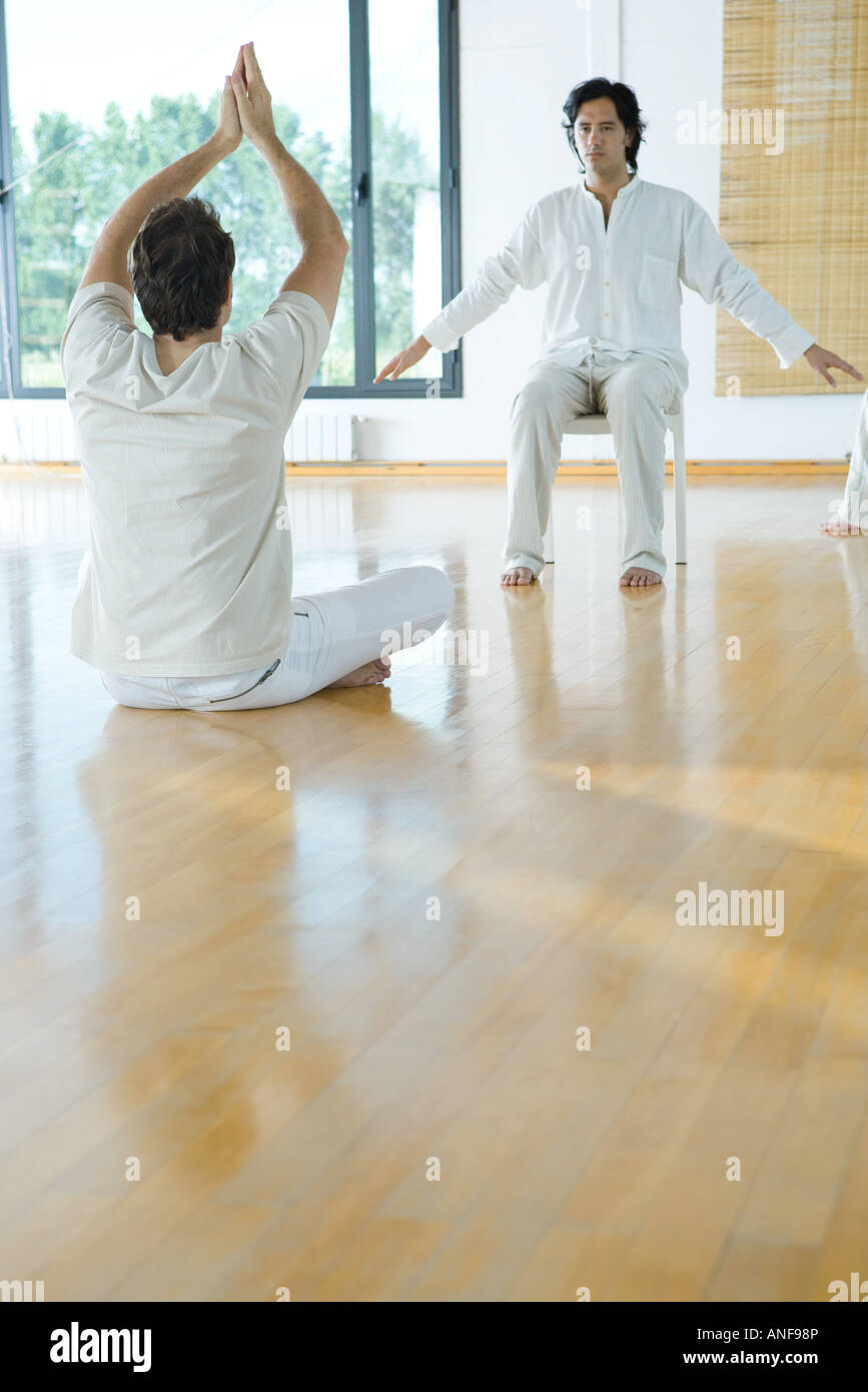 Two men sitting in serene positions in wellness center Stock Photo - Alamy